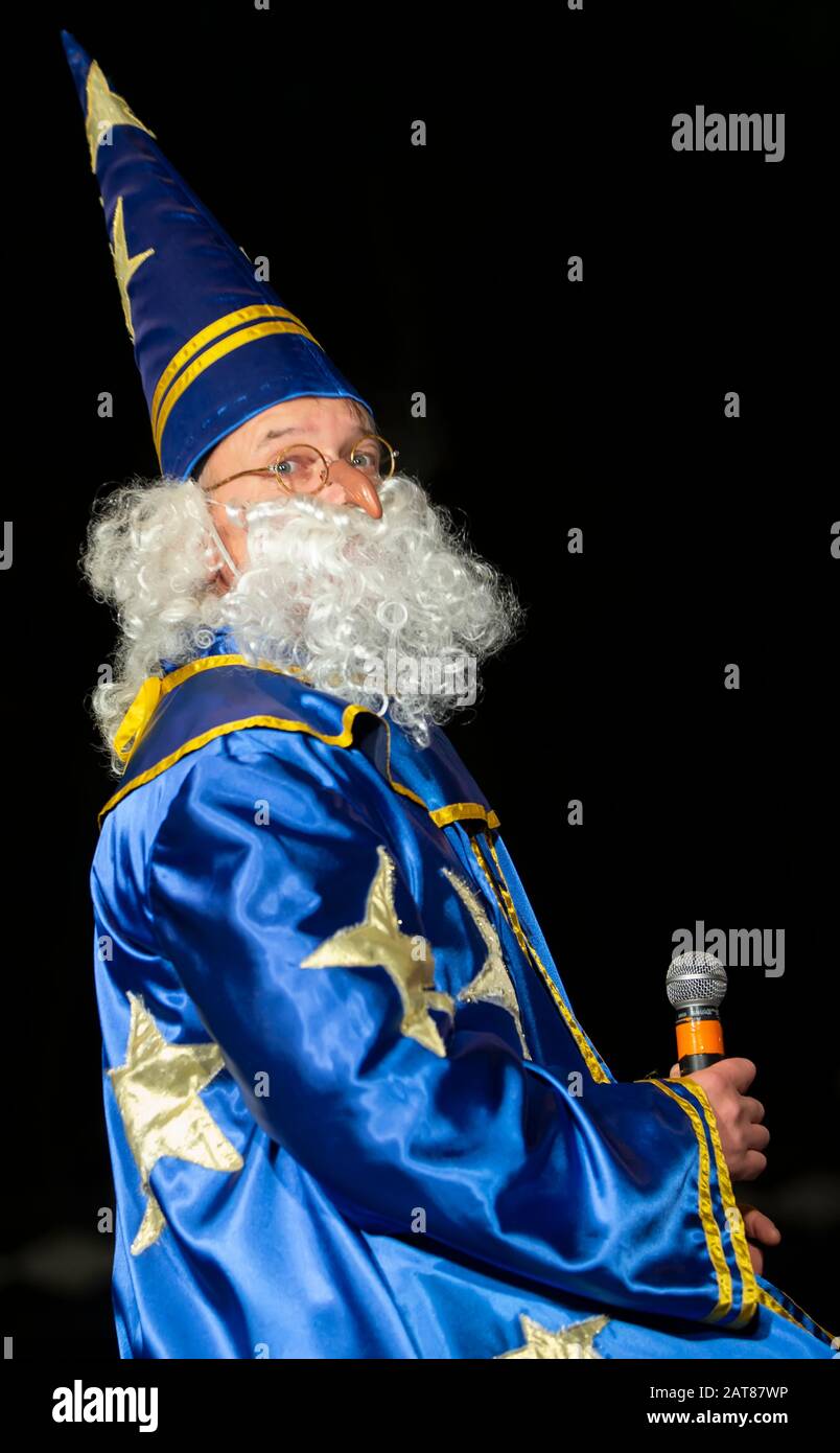 A man in a wizard costume with a microphone. Astrologer Stock Photo - Alamy