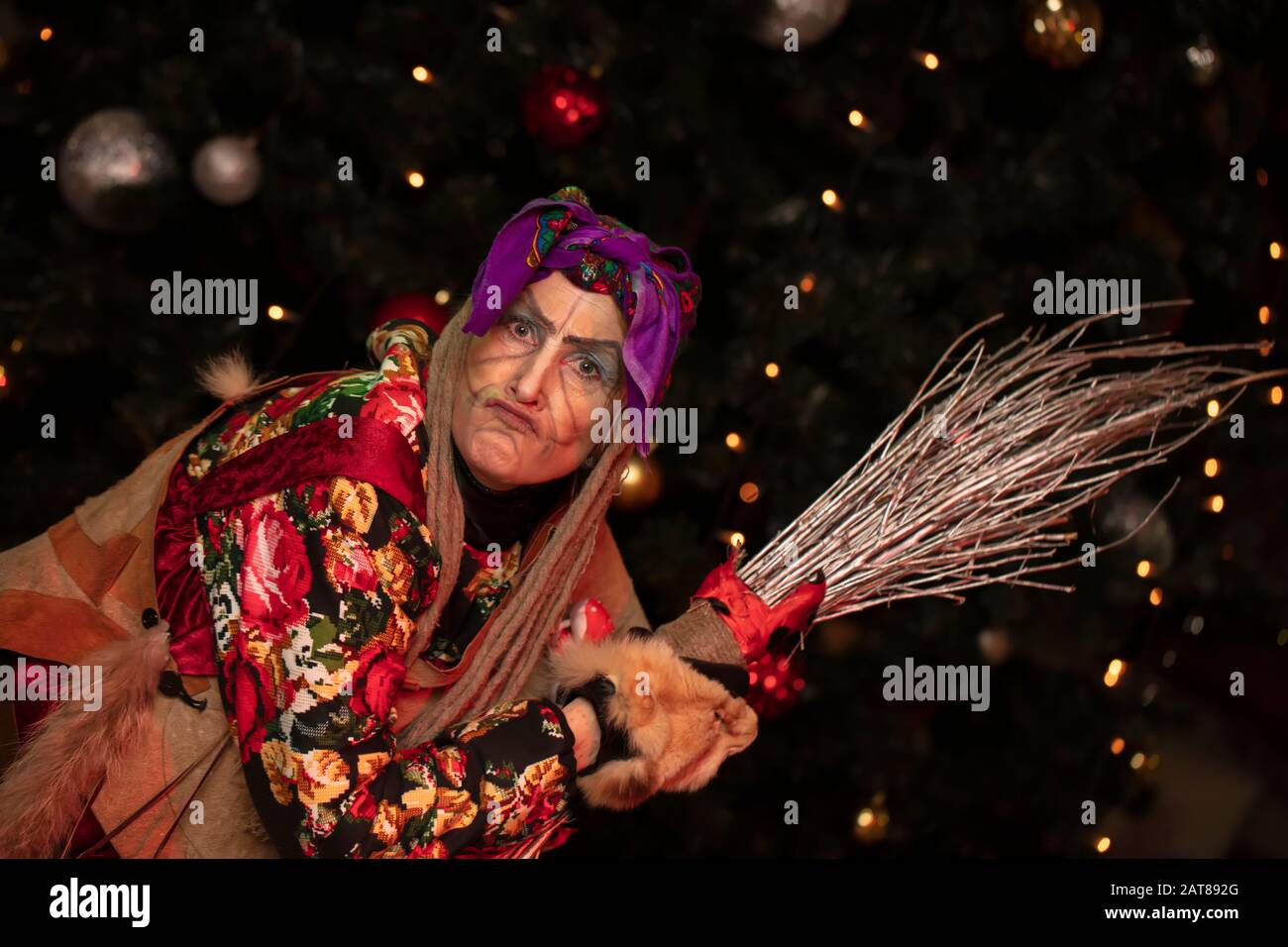 Baba Yaga with a broom on the background of the Christmas tree.Russian ...