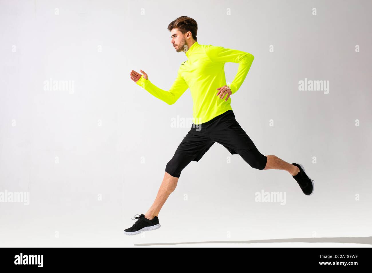 young normal person doing sport, running and jumping on white ...