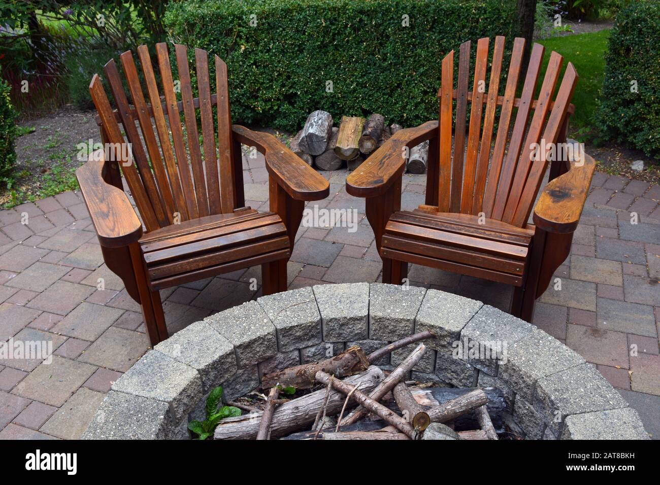 Two wooden adirondack chairs and campfire Stock Photo - Alamy