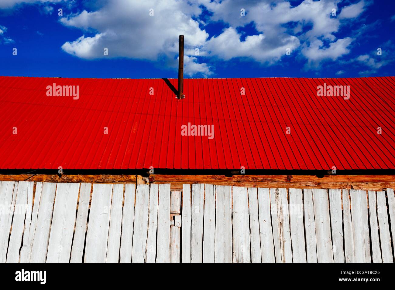 Low angle close up of white wooden building with bright red roof under ...