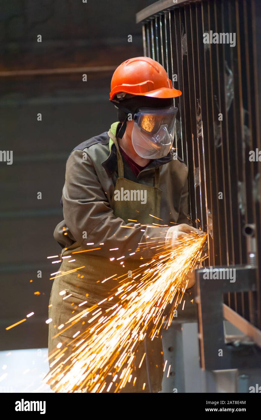 Industrial worker cutting metal with many sparks Stock Photo - Alamy
