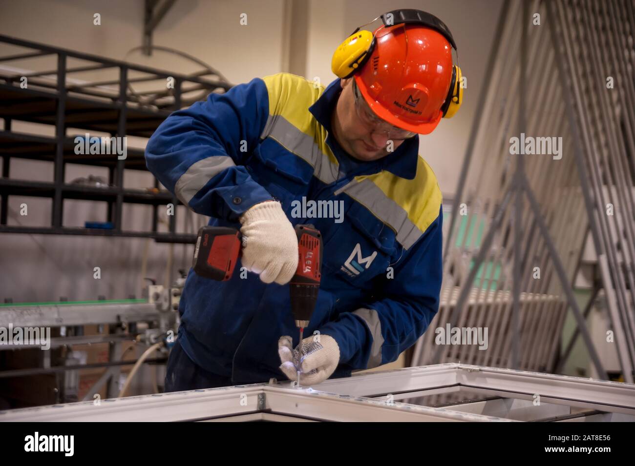 Worker working with PVC window at factory Stock Photo - Alamy