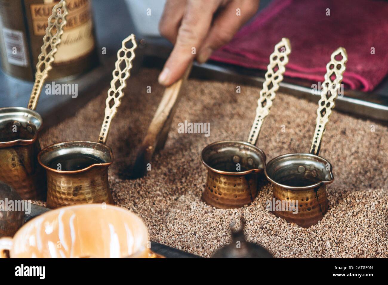 Making traditional black Turkish coffee or espresso in the sand in a ...