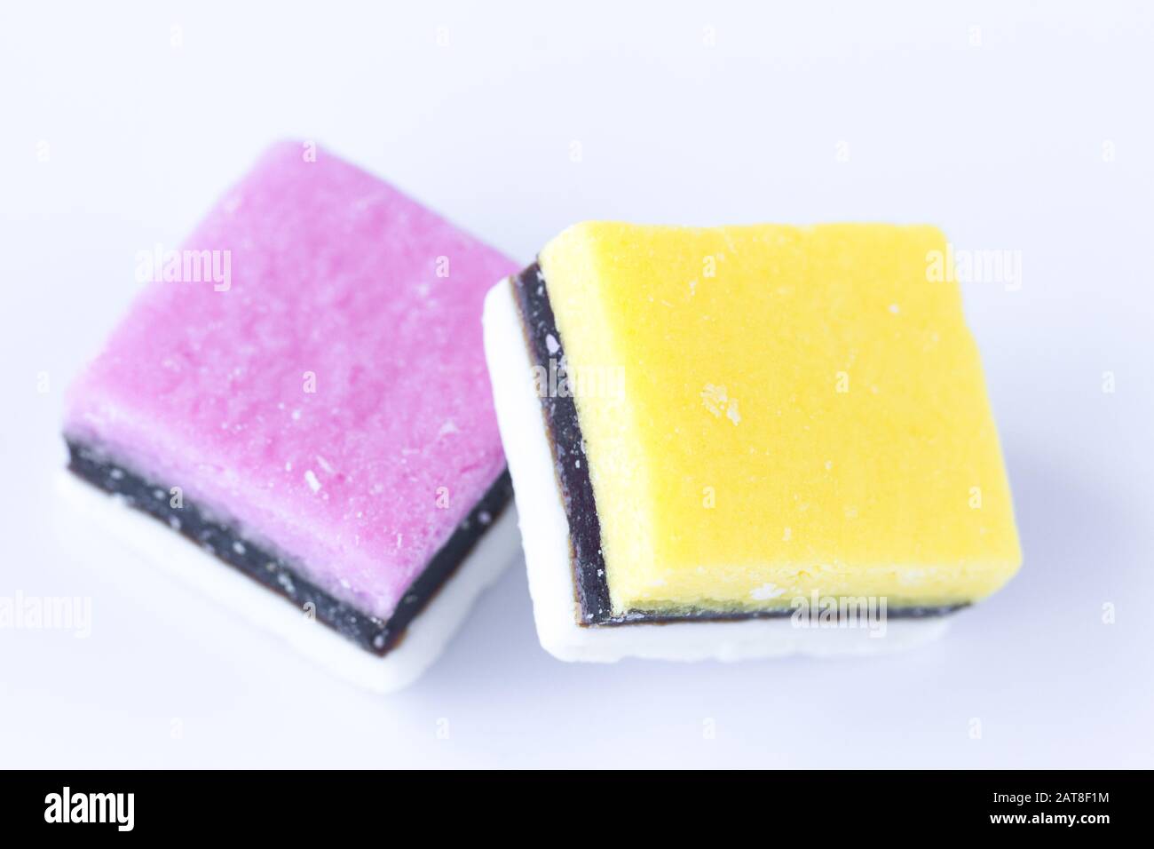 Two Liquorice Allsorts sweets pink and yellow Stock Photo - Alamy