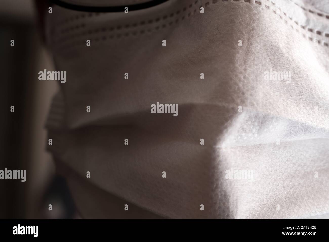 Closeup with the face of a young man wearing medical or surgical mask ...