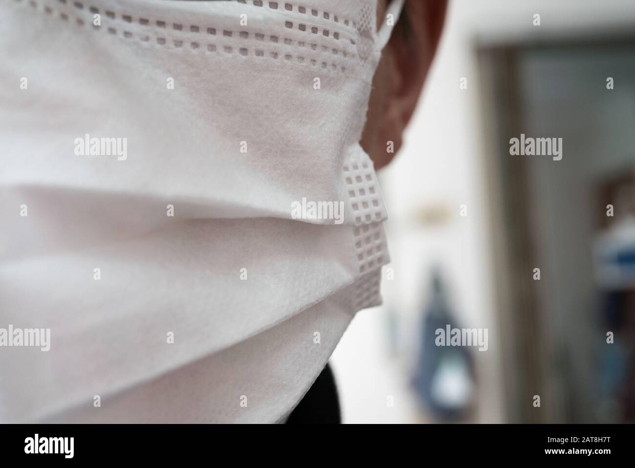 Closeup with the face of a young man wearing medical or surgical mask ...