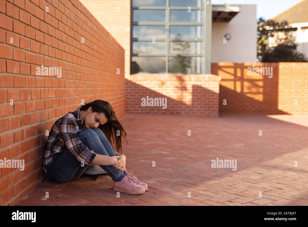 Teenage girl sitting in school grounds Stock Photo - Alamy