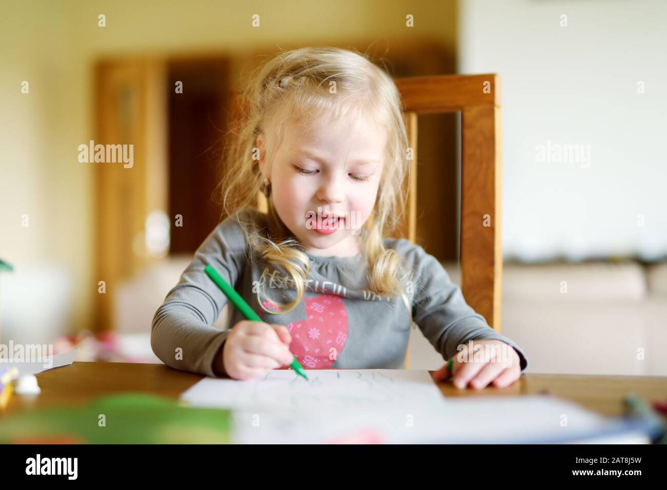 Cute little girl drawing with colorful pencils at a daycare. Creative ...