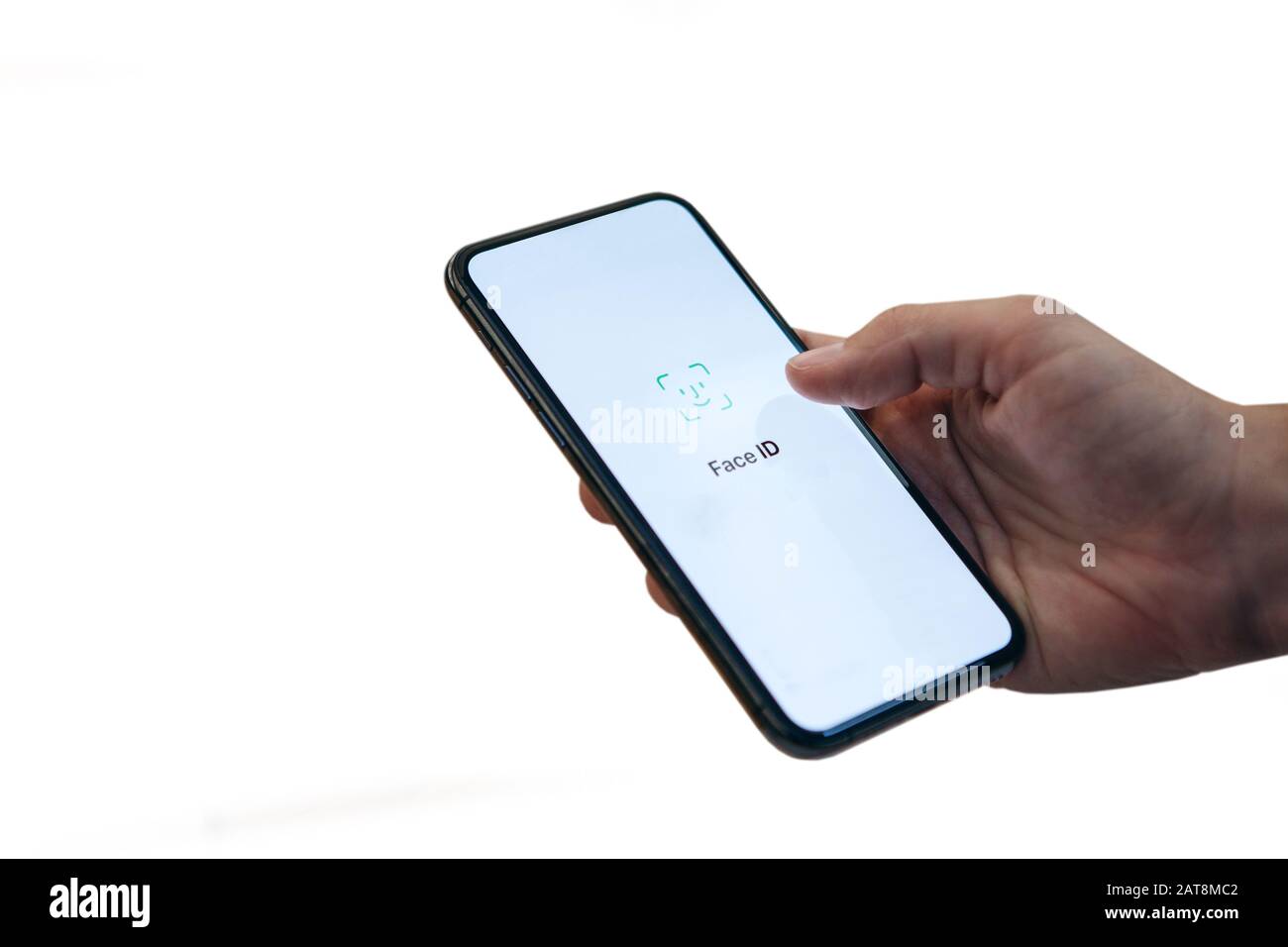 Person uses face id on cell phone. Hand with a phone on a white ...