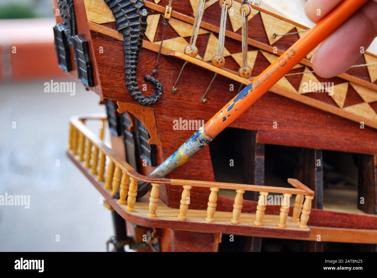 Young man constructing a ship model in a ship-modelling studio ...