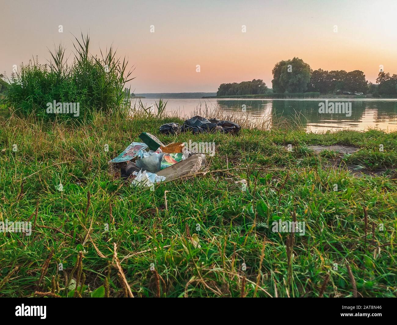a pile of garbage on the river bank. Environmental pollution ...