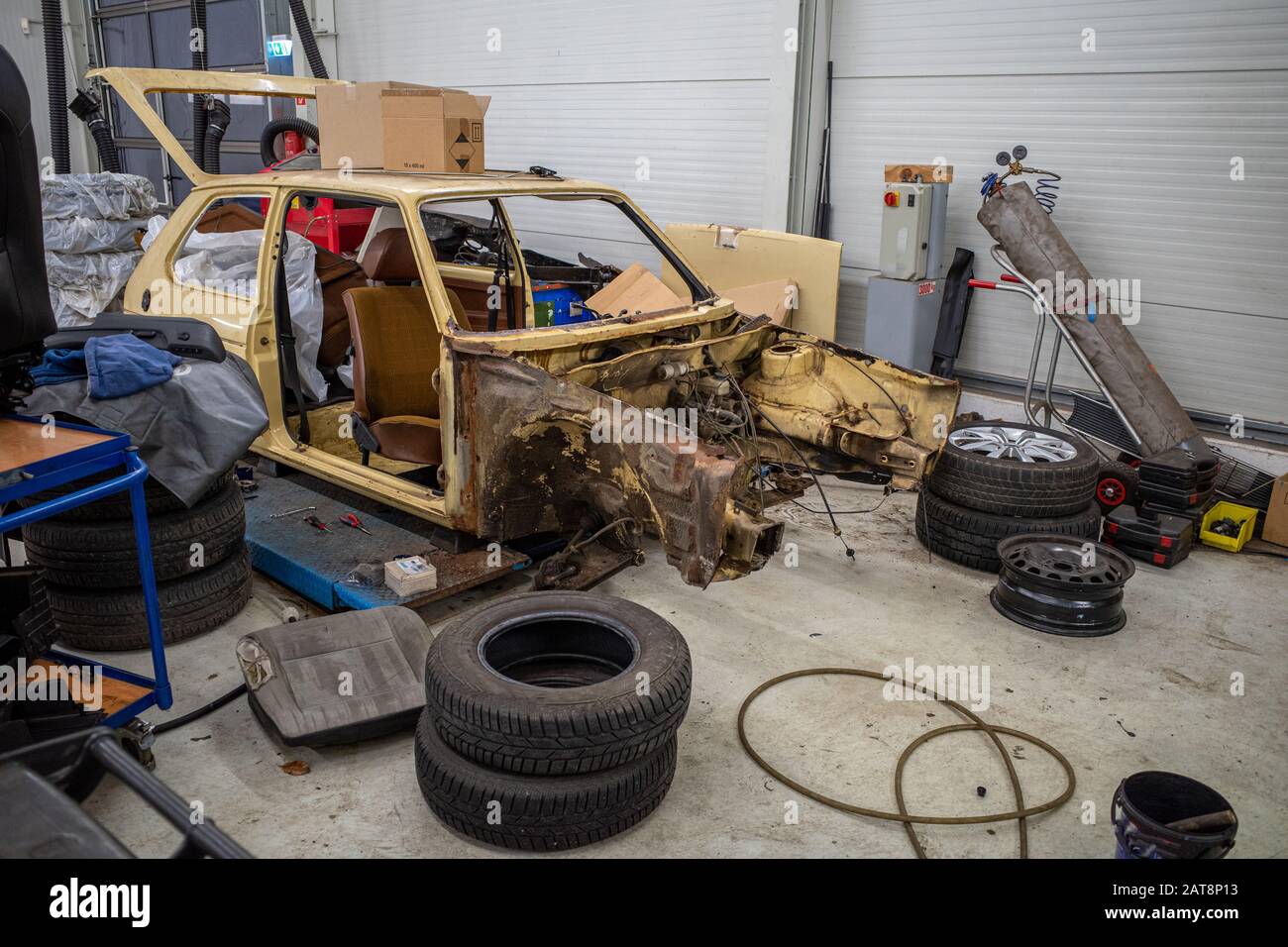 in a garage there is a disassembled old car wreck to be restored Stock ...