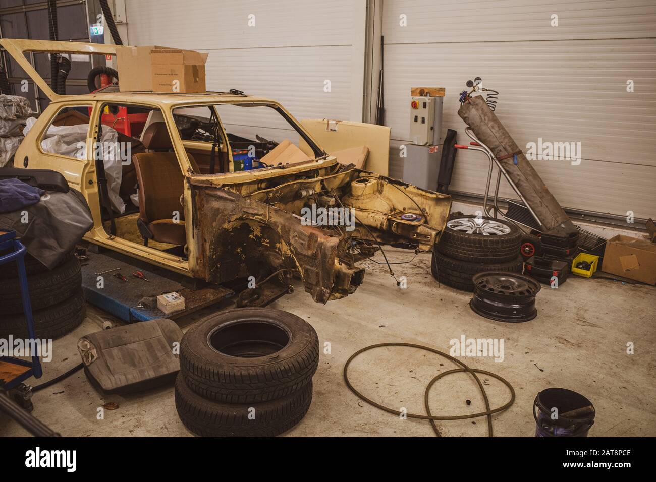 in a garage there is a disassembled old car wreck to be restored Stock ...