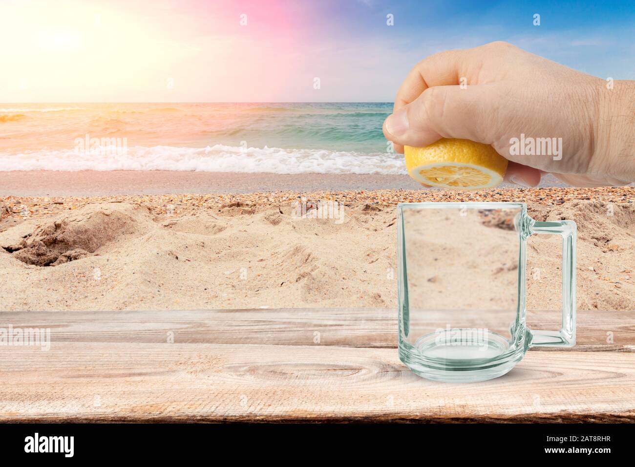 Hand squeezed lemon juice into a glass against the background of the ...