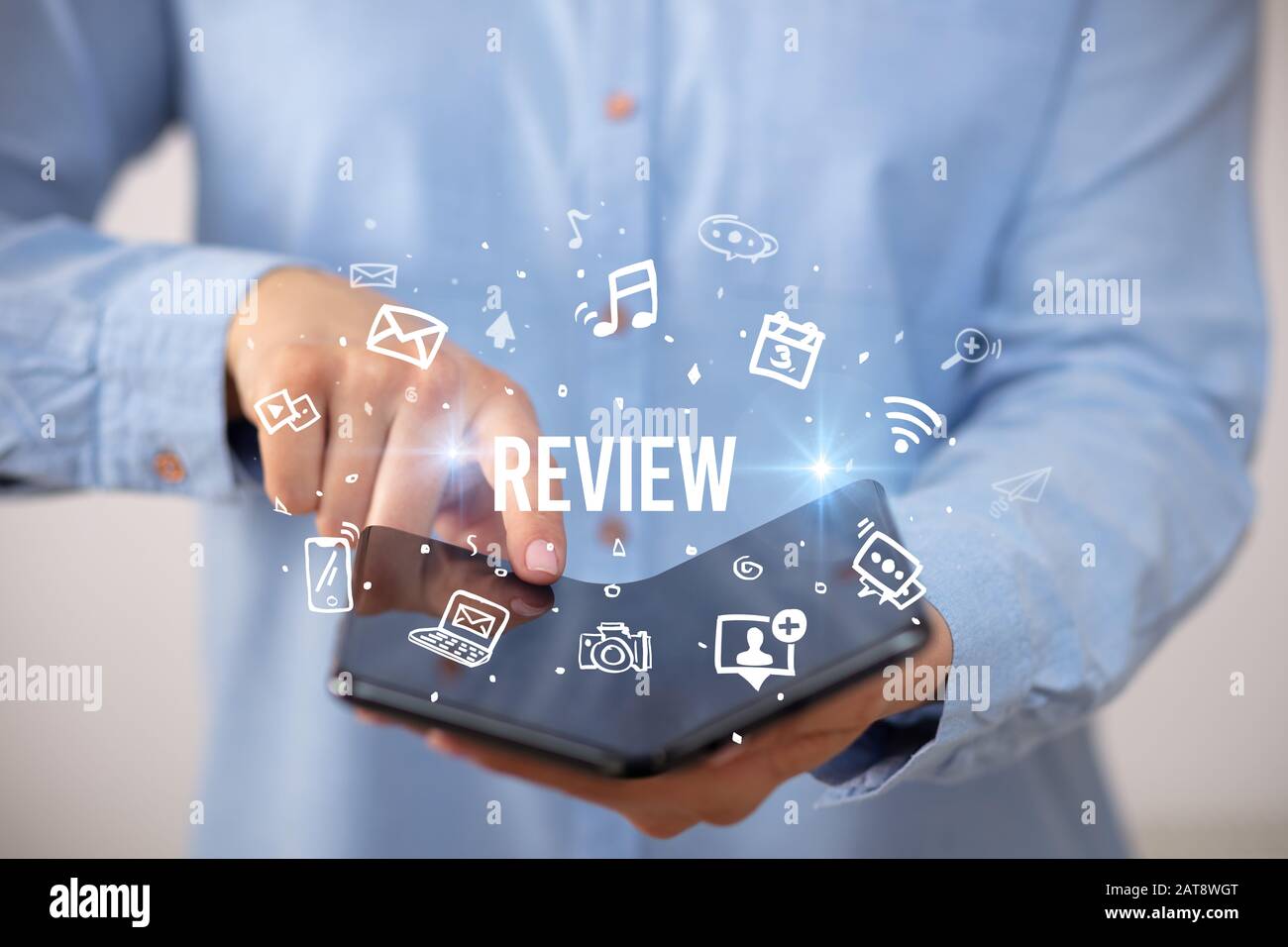 Businessman holding a foldable smartphone with REVIEW inscription ...