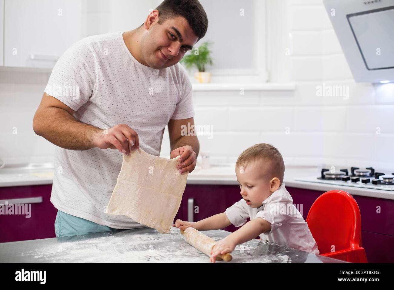 Kid rolls out the pizza dough. Happy family in kitchen Stock Photo - Alamy Kid rolls out the pizza dough. Happy family in kitchen Stock Photo - Alamy