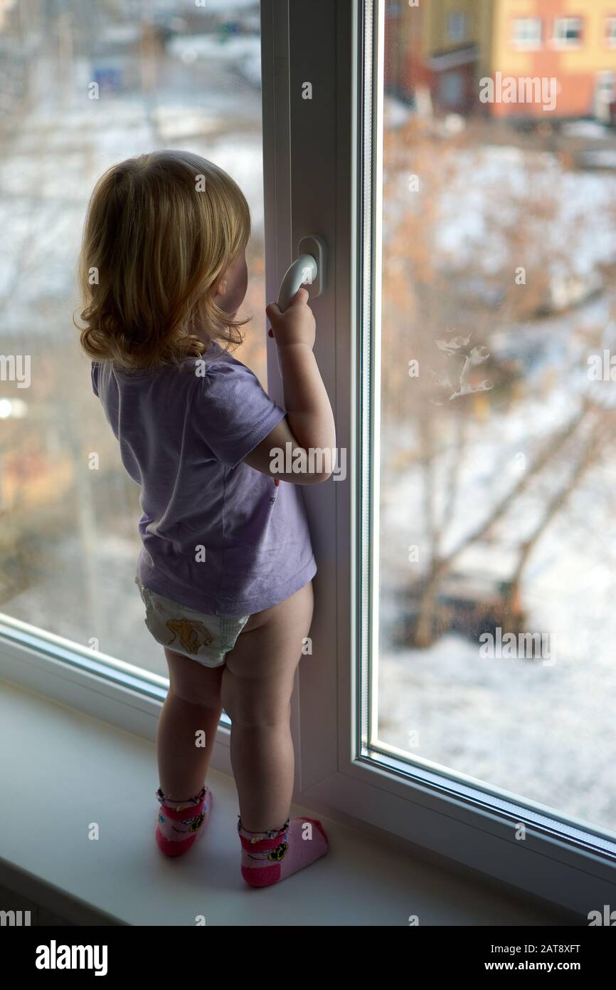 A little girl standing in front of a window Stock Photo - Alamy