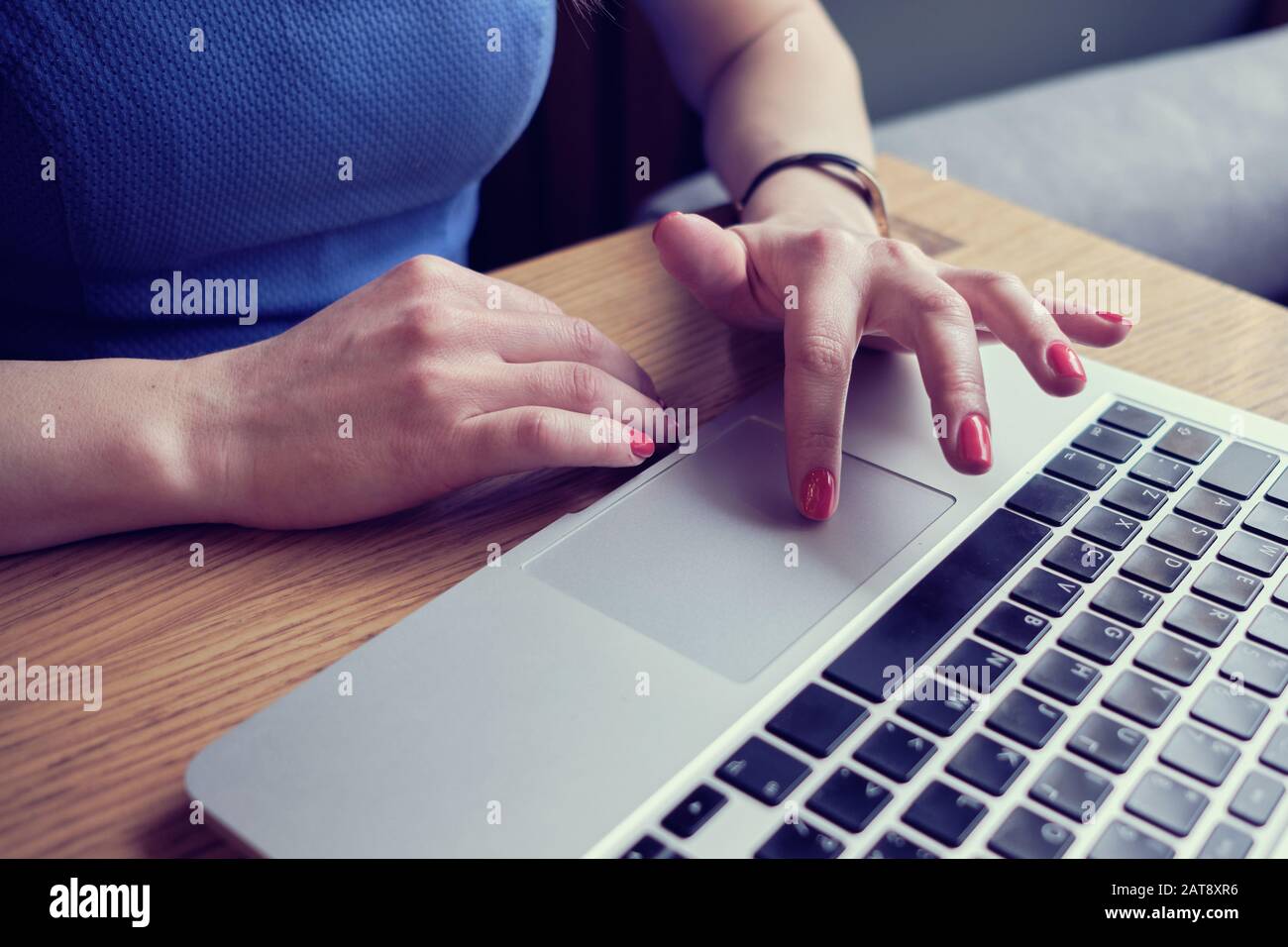 The girl works at the laptop in the cafeteria. Hands are typing on the ...