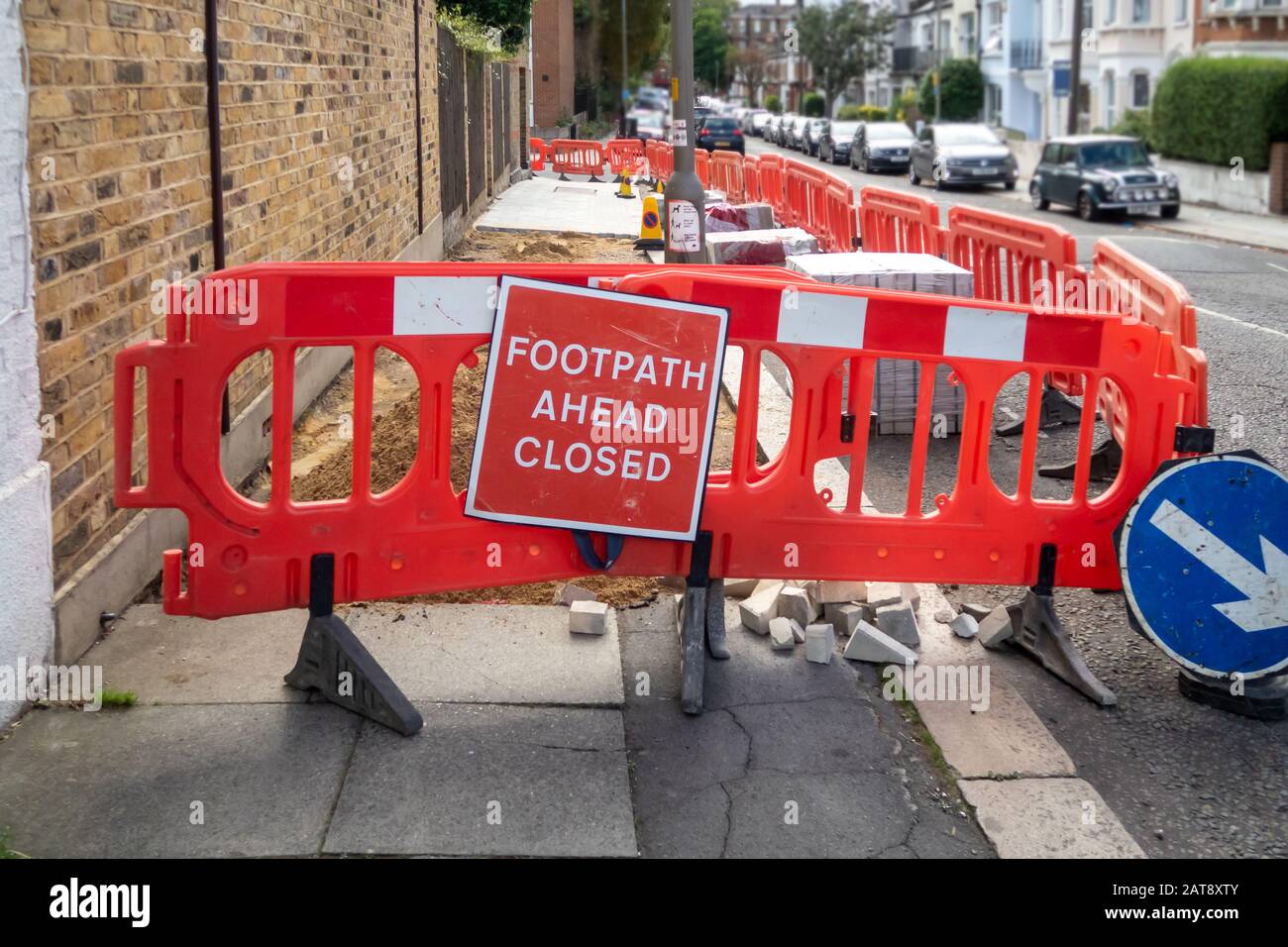 Works to lay new paving slabs and temporary footpath closed red warning ...