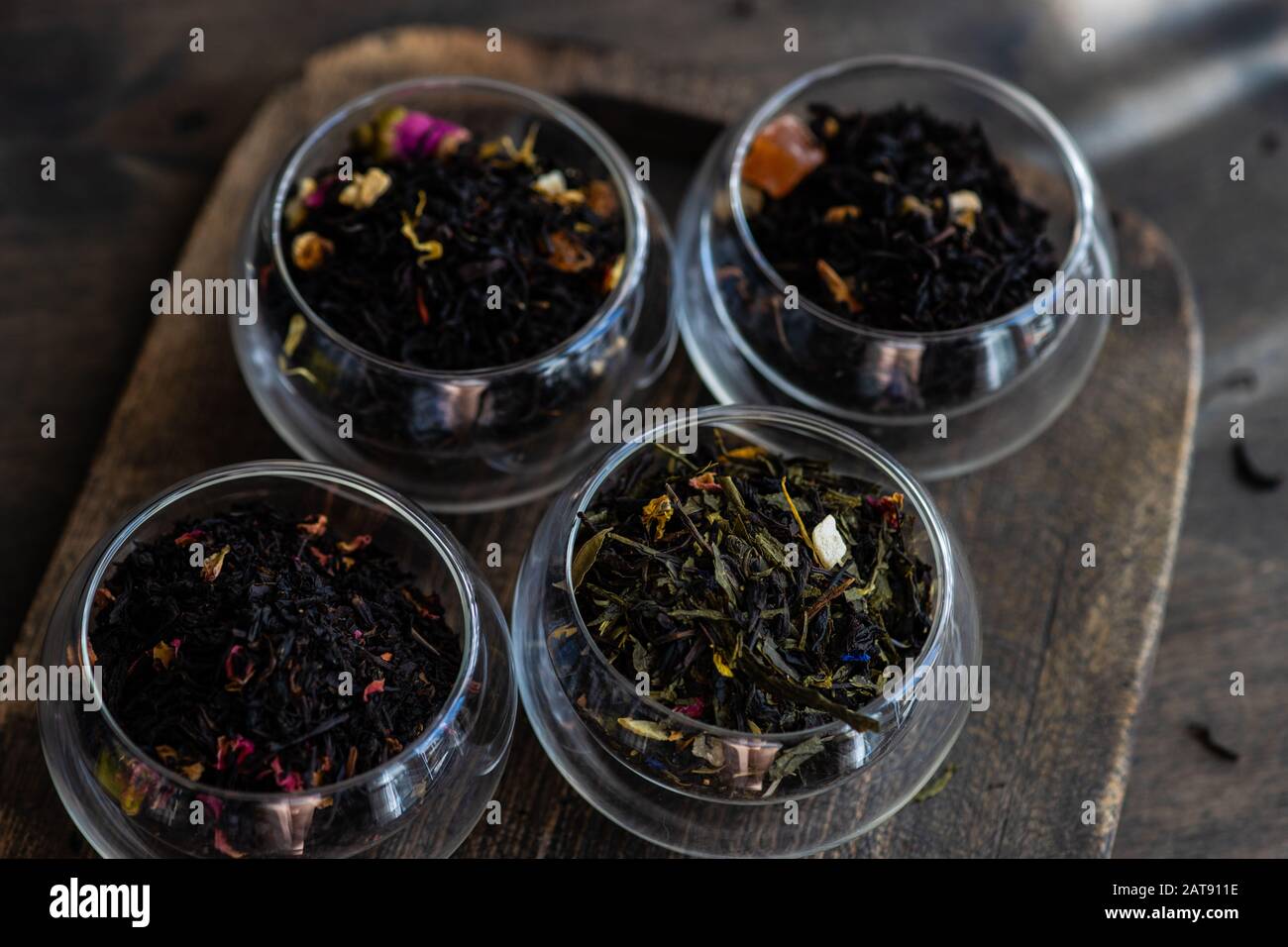 Different tea varieties in glass bowls on wooden rustic background with ...