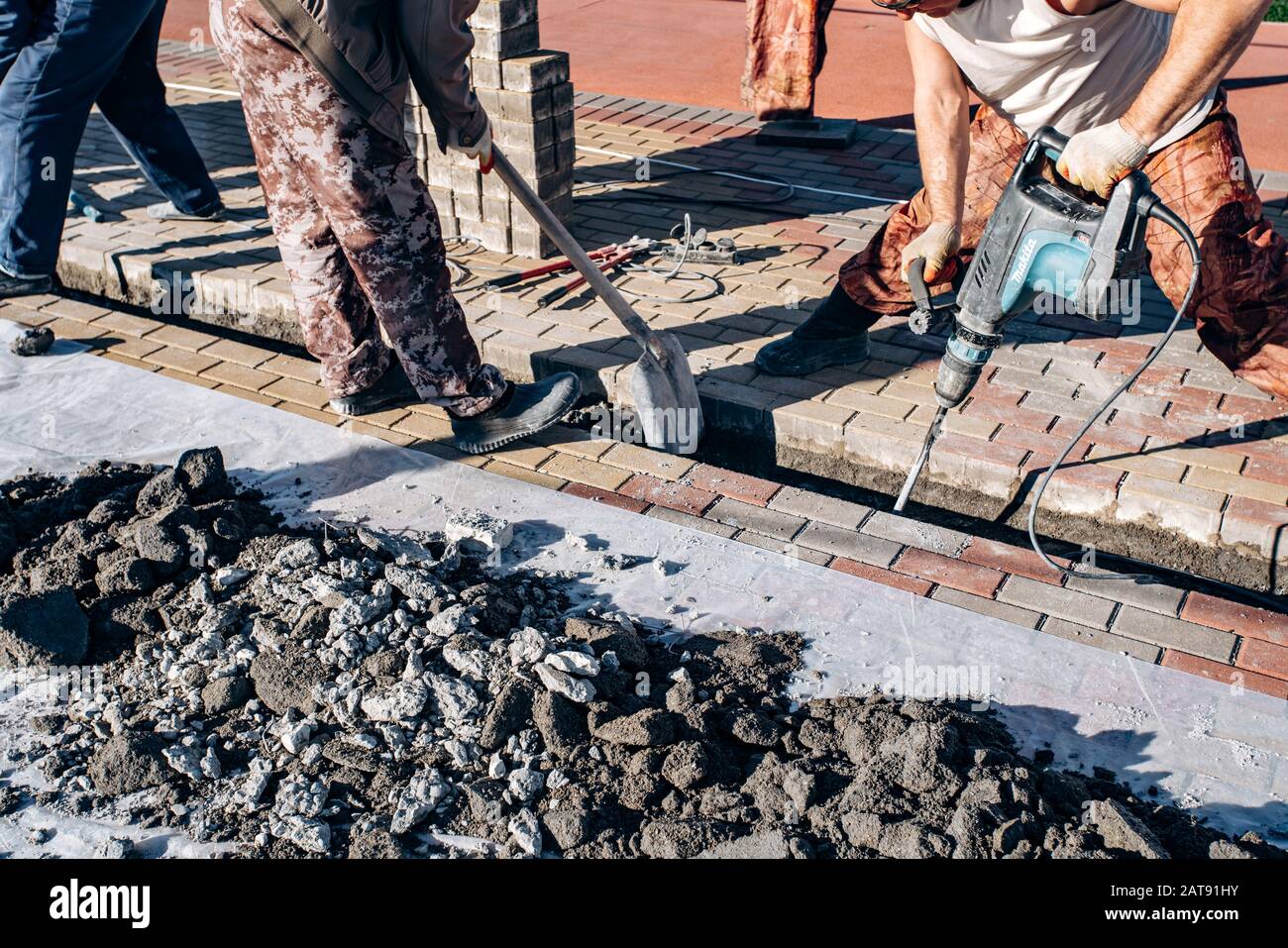 Workers laid paving slabs. Two workers lay paving slabs Stock Photo - Alamy