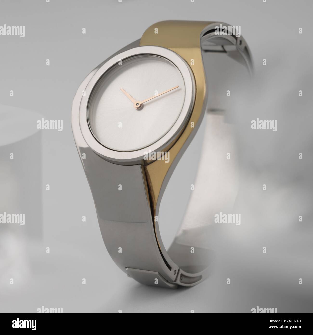 Modern design silver and gold hand watch front view on white blurry ...