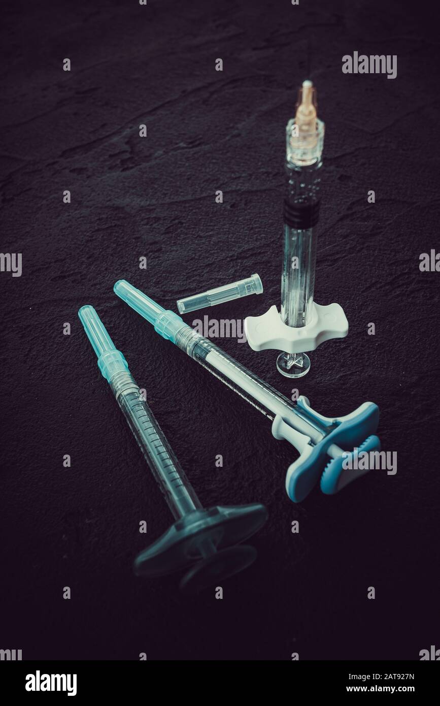 cosmetology injections. Plastic syringe on black background. Medical ...