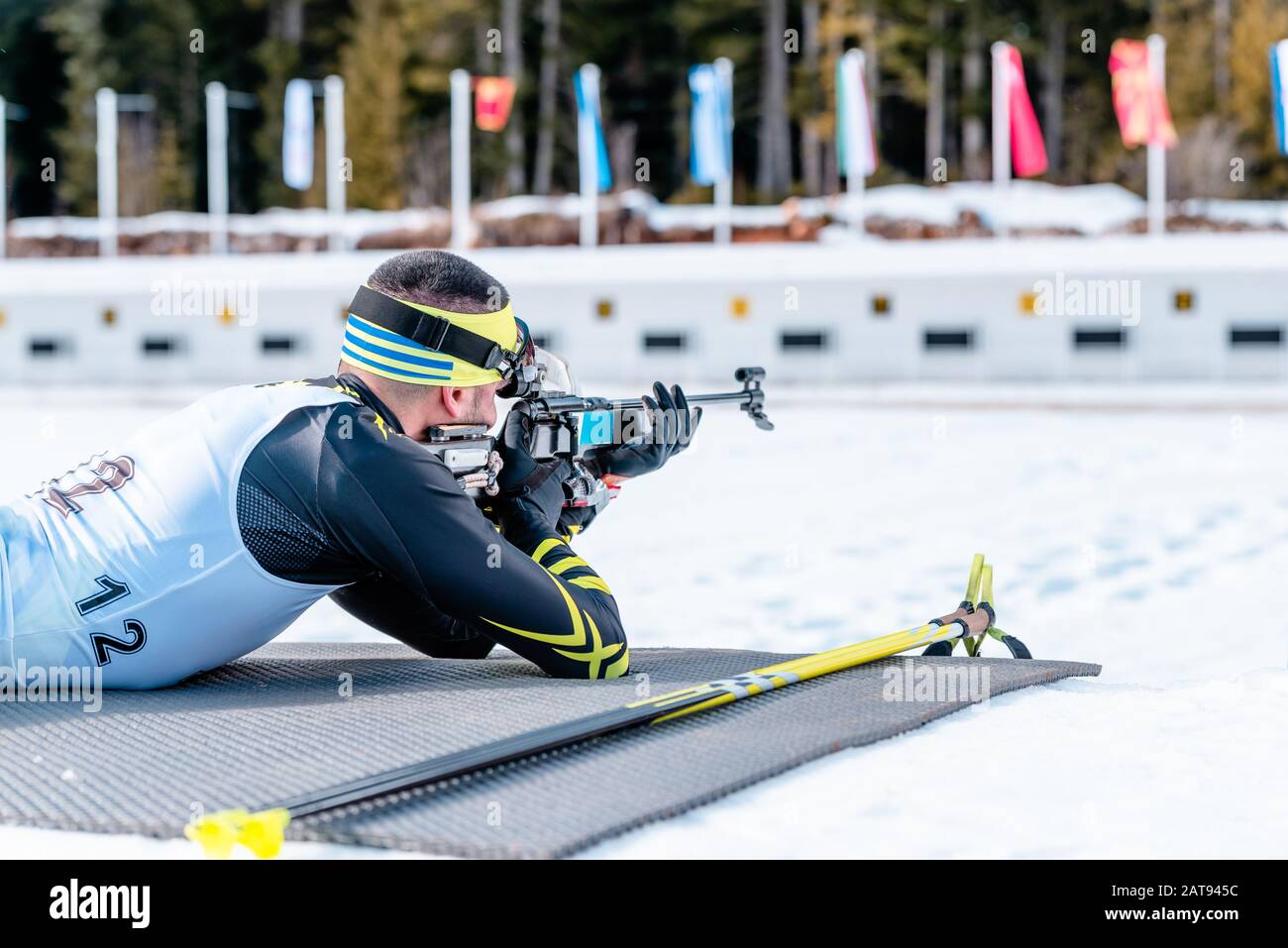 Biathlete shooting with a rifle at a shooting range at the race Stock ...