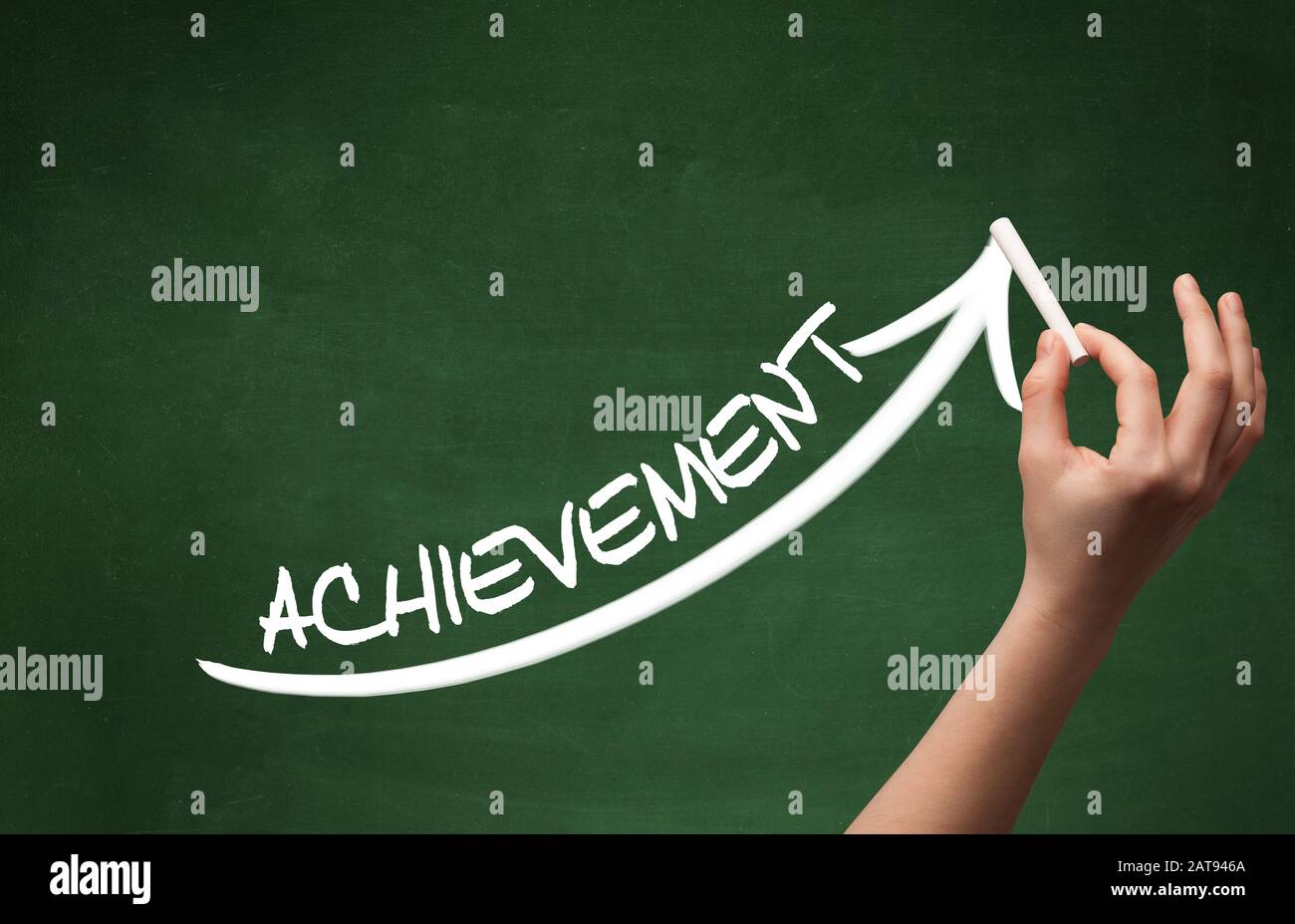 Hand drawing ACHIEVEMENT inscription with white chalk on blackboard ...