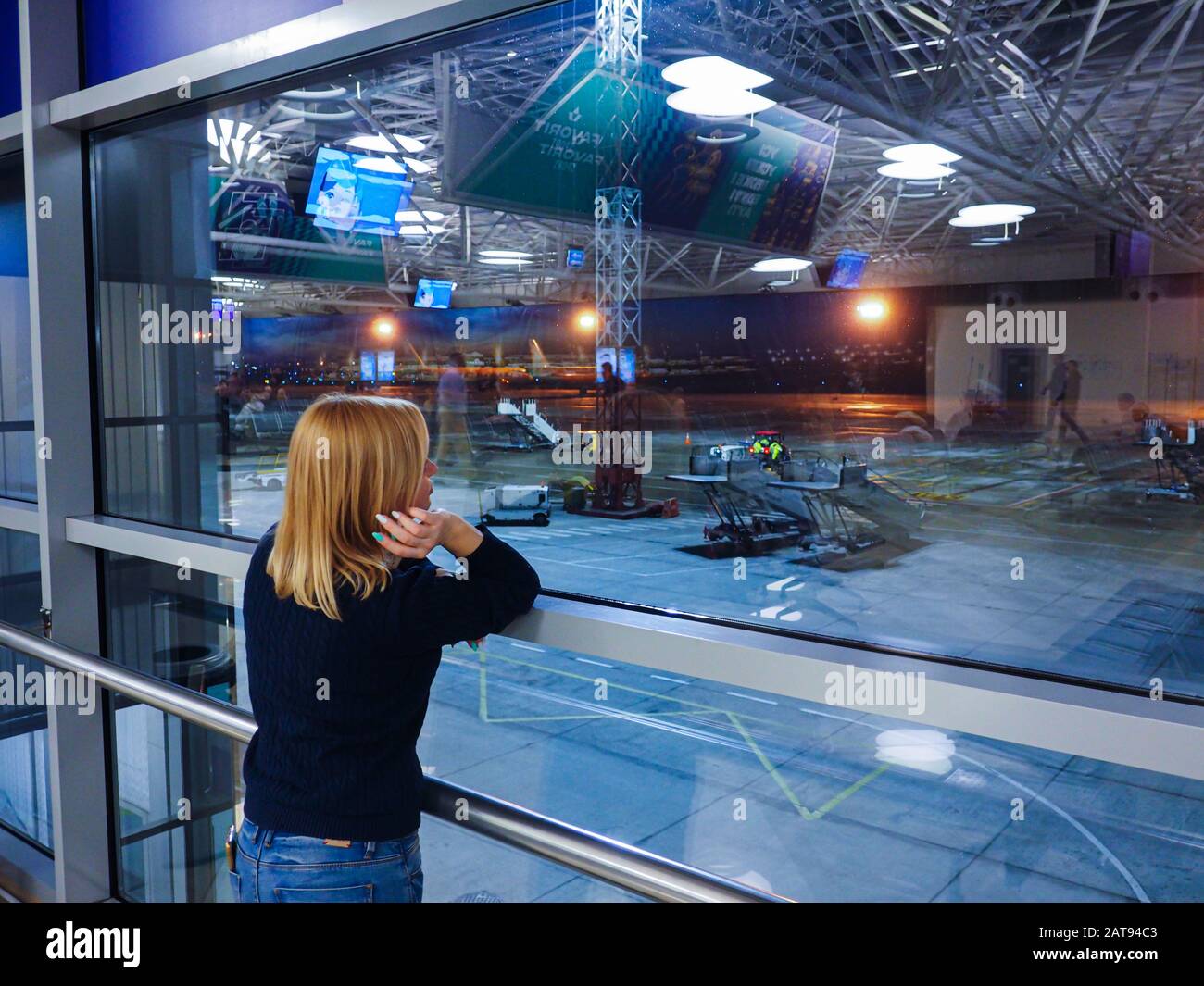Young caucasian woman near a panoramic window watches work at the ...