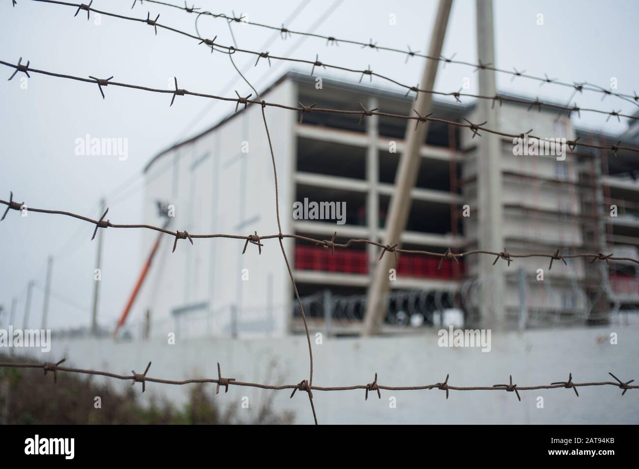 barbed wire against the background of a building under construction ...
