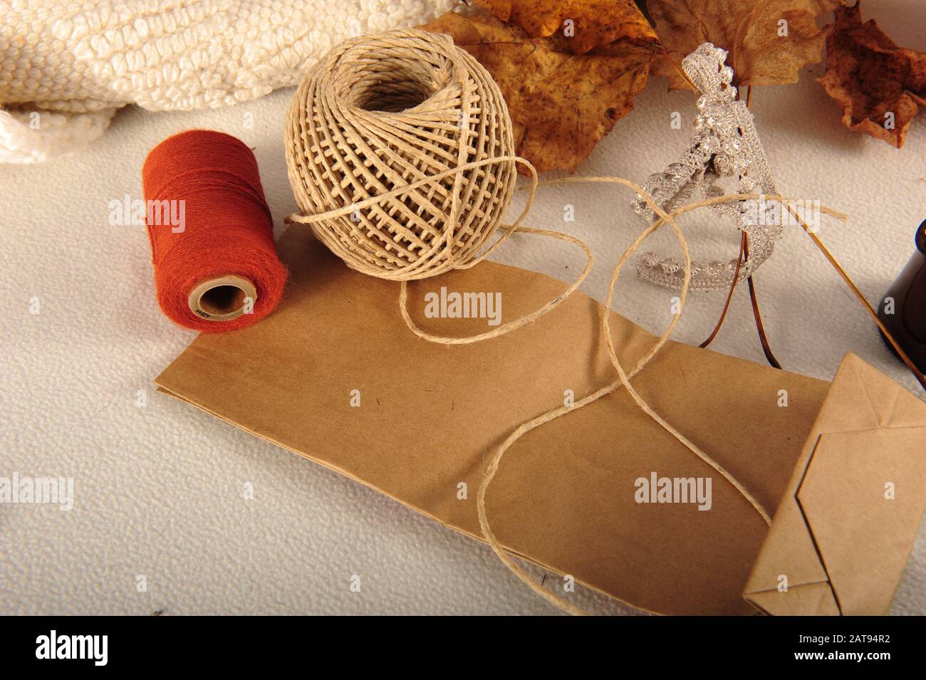Spools of thread and natural string. Brown envelope and faded leaves ...