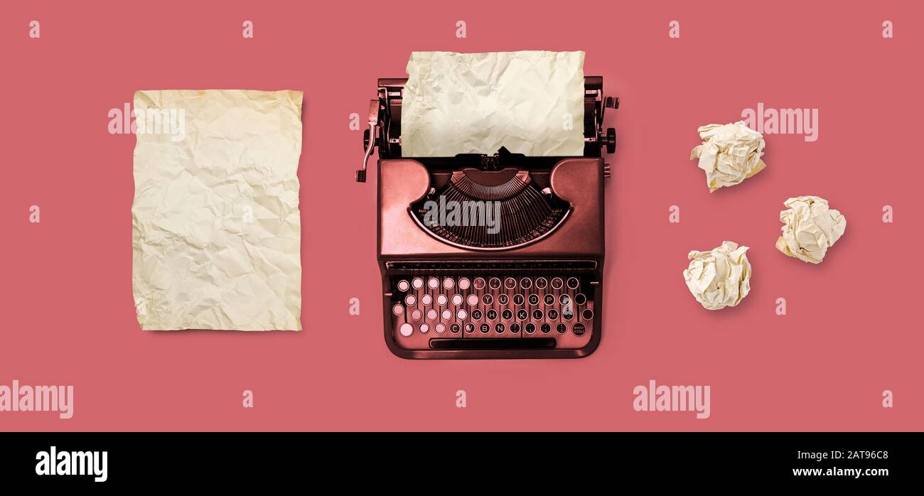 Vintage typewriter and crumpled papers over colour background with copy ...