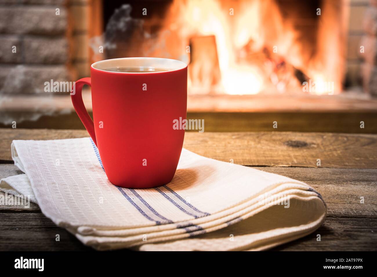 Cozy scene before fireplace with a cup of tea, in country house, winter ...