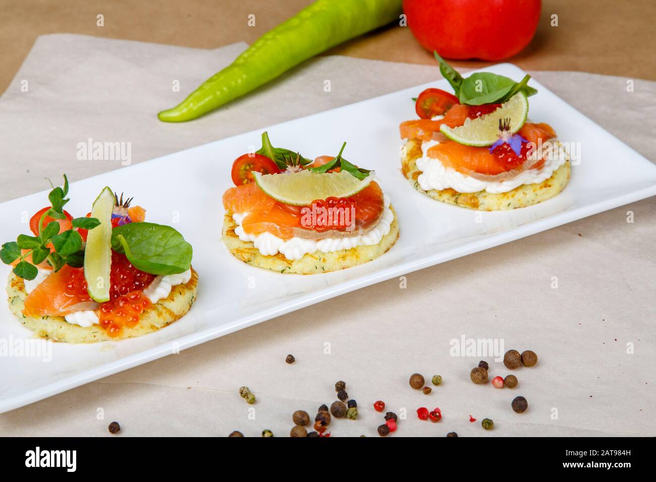 round sandwiches with salmon and red caviar. White the long square ...