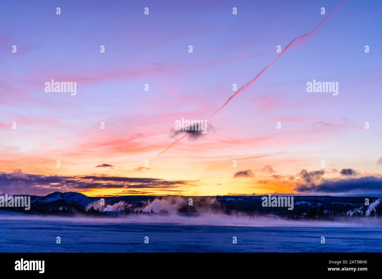Steam rises from geothermal features at sunset. Yellowstone National ...