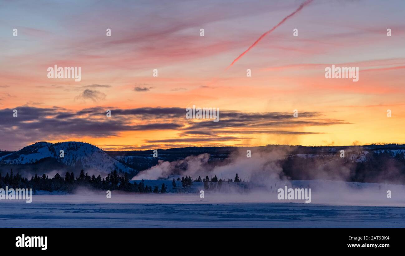 Steam rises from geothermal features at sunset. Yellowstone National ...