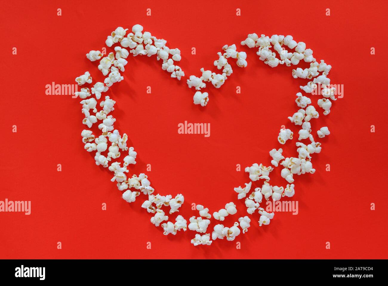 Love cinema concept of popcorn. Heart shaped white fluffy popcorn on ...