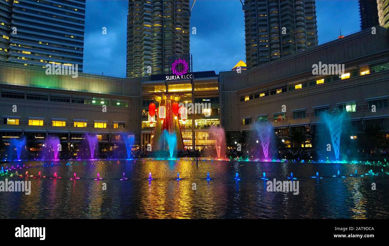 Multi-colored dancing fountains near the twin towers of Petronas in ...