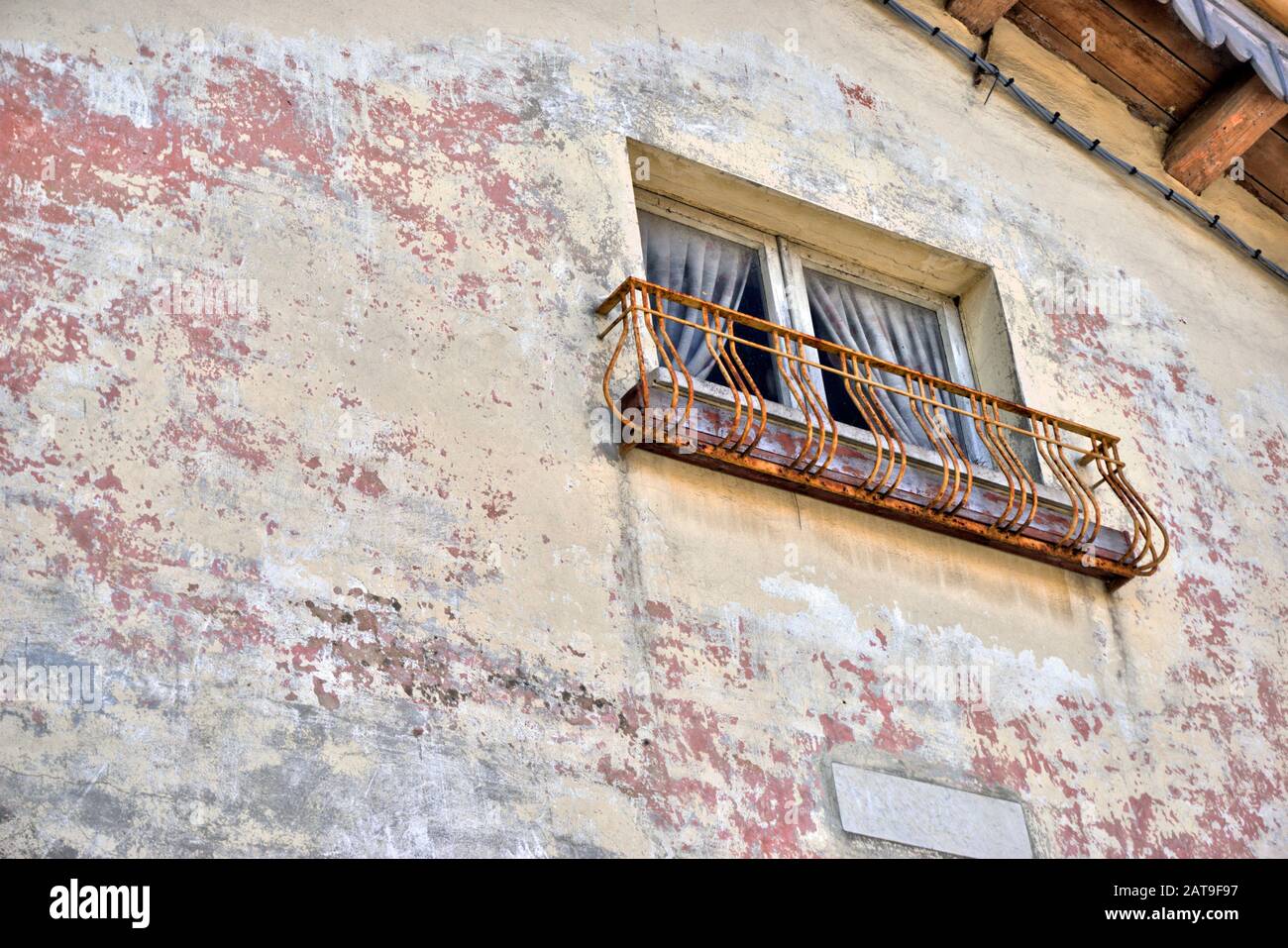 Italian building facade in poor condition with window and rusty metal ...