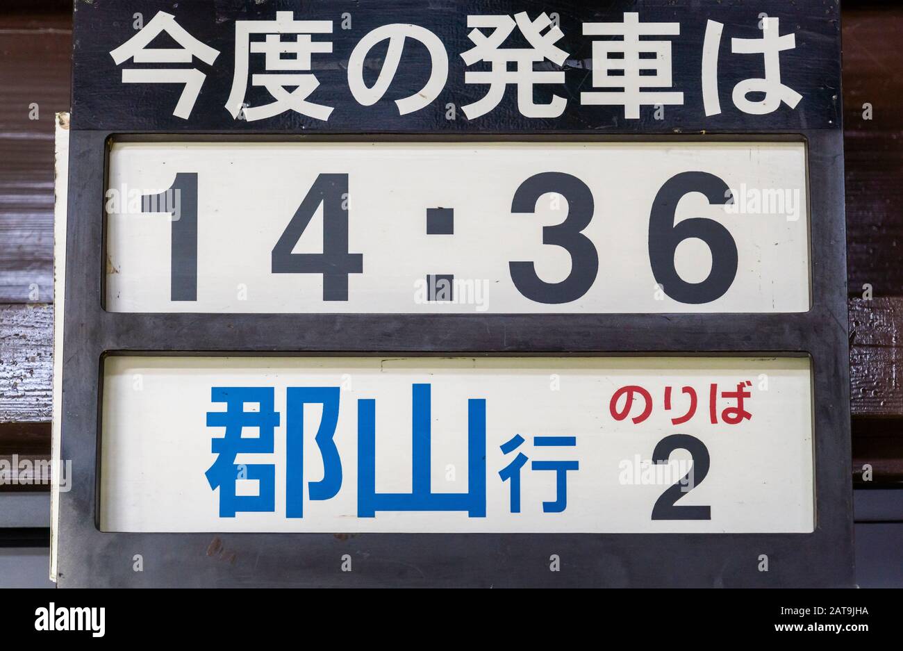 An old, non-electronic sign giving departure time and track number for ...