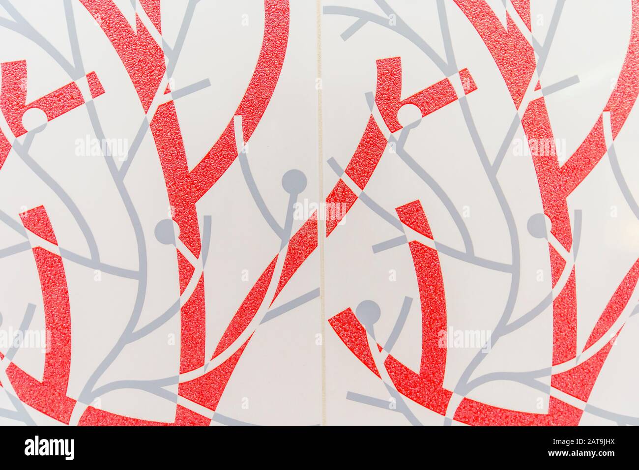 a square ceramic tile with a red and white floral pattern hangs on the ...