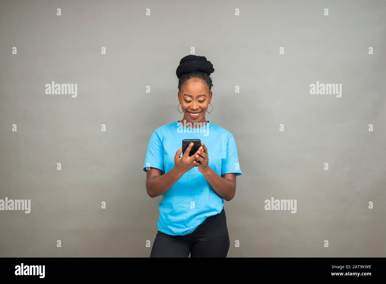 beautiful young black woman using her mobile phone smiling Stock Photo ...
