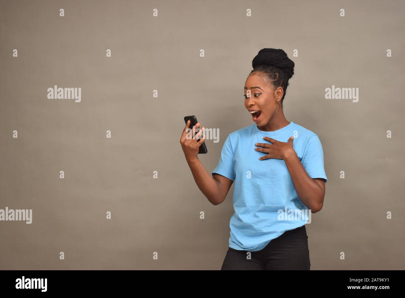 beautiful young african lady using her mobile phone feeling happy and ...