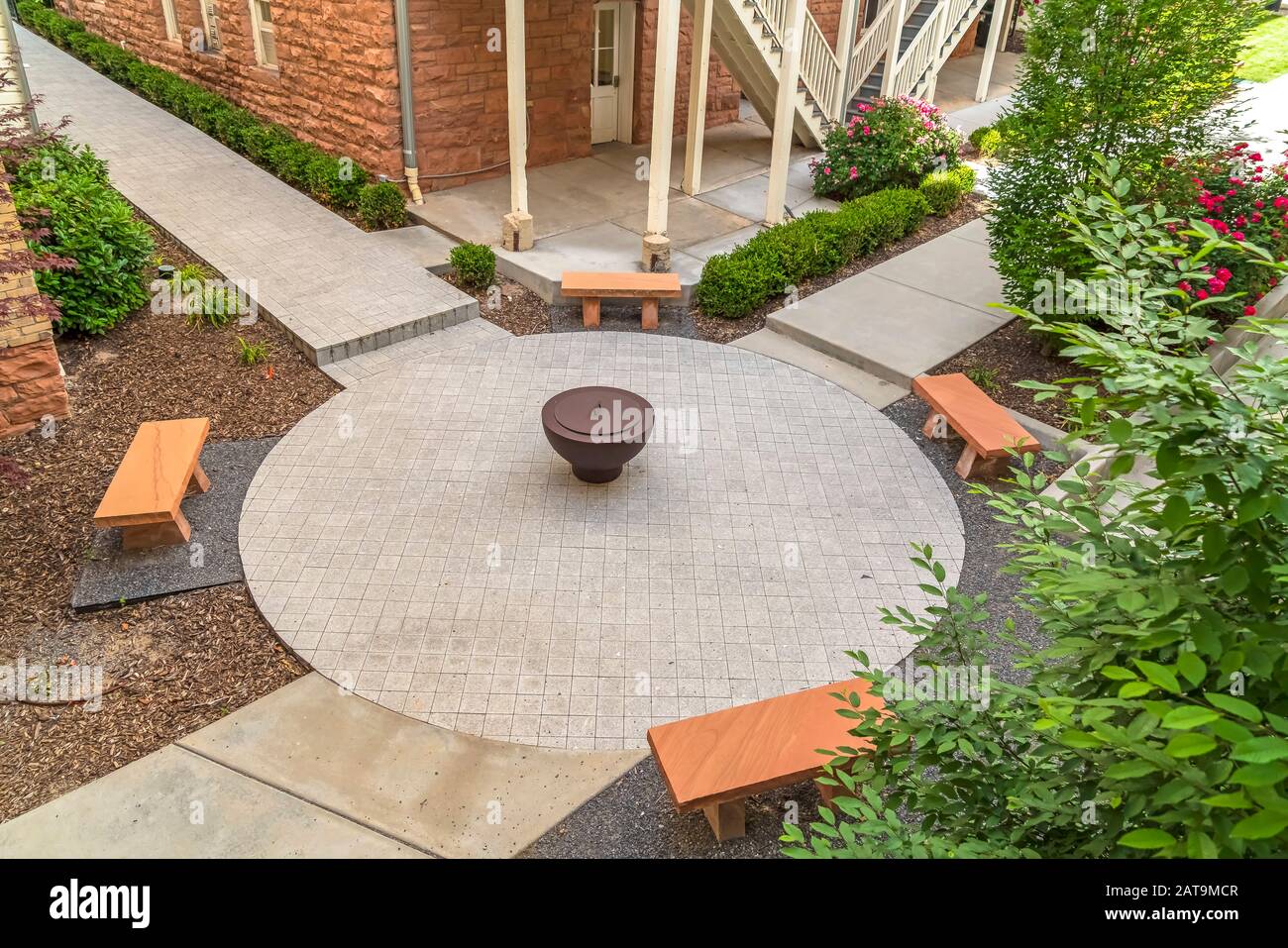 Aerial view of benches and fire pit on circular paved patio outside a ...