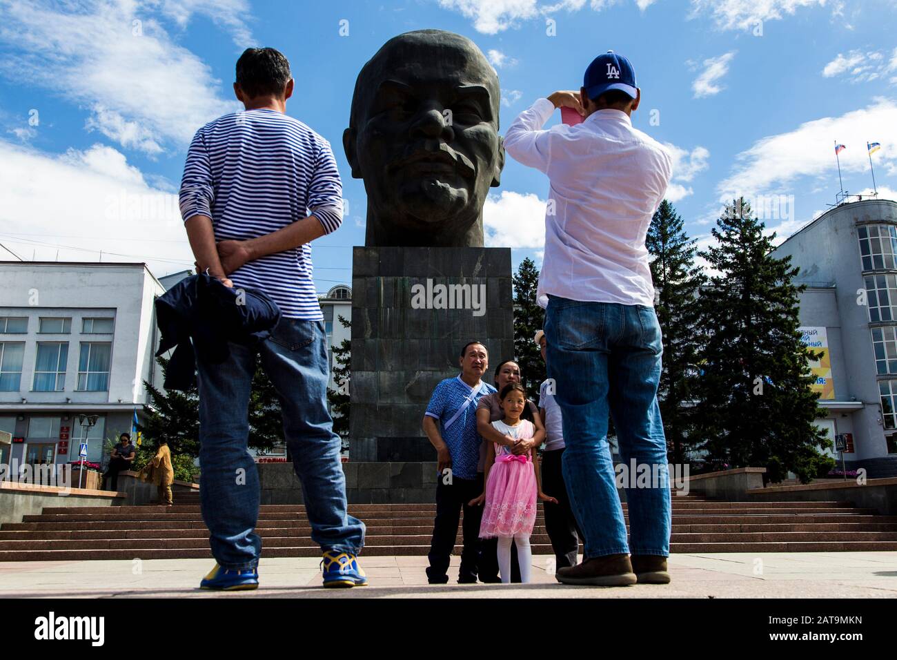 People takeing pictures in front of the largest head of Soviet leader ...