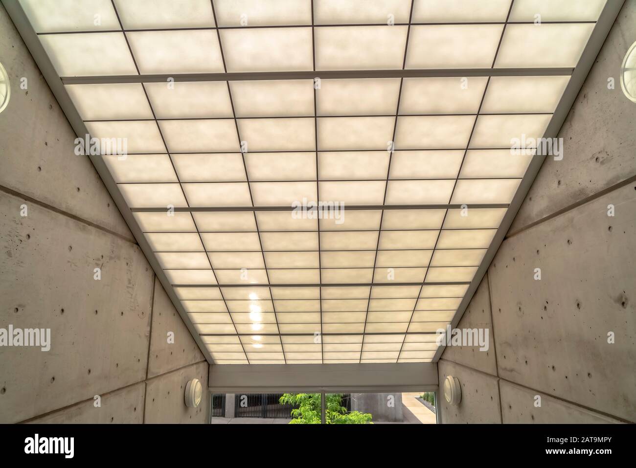 Slanted glass roof of building with concrete side wall and clear glass ...