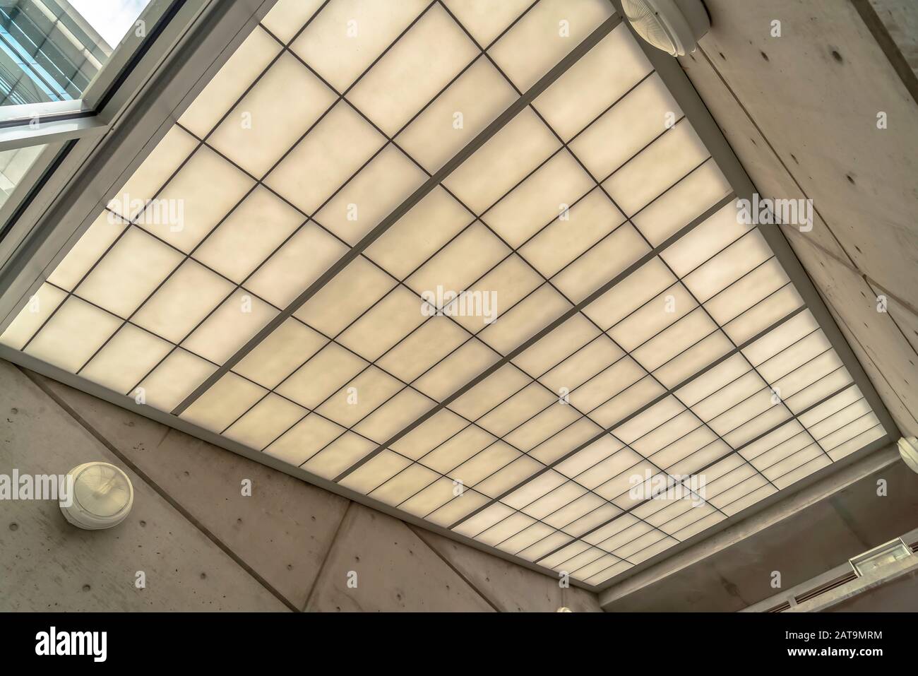 Slanting frosted glass roof of a building with round lights on the side ...