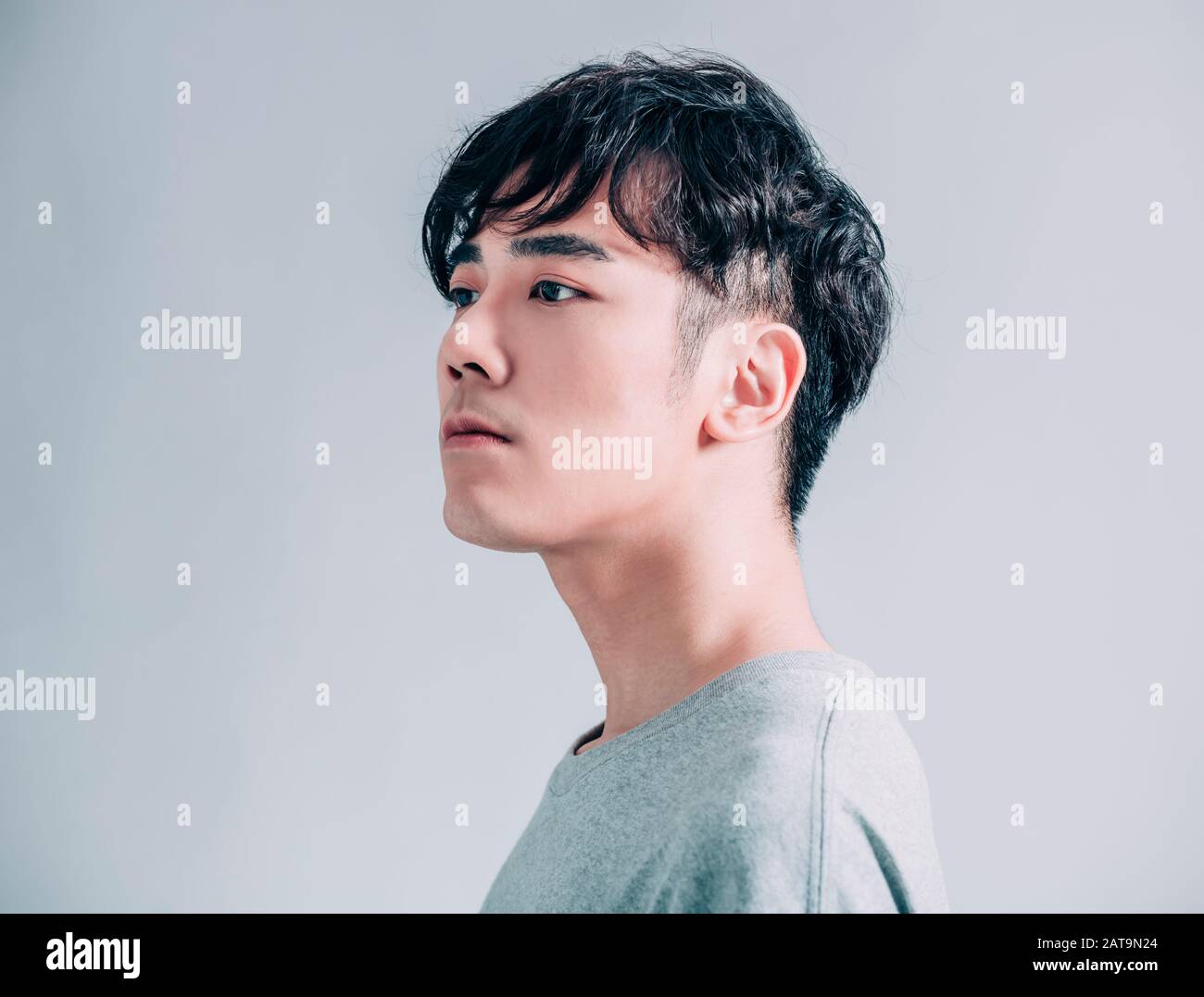side view of young asian handsome man isolated on gray background Stock ...